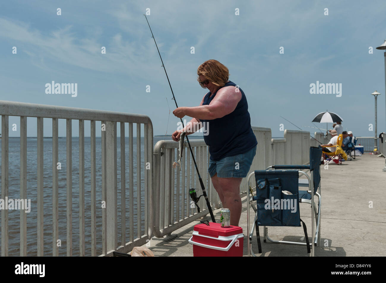 A woman fishing on the public pier at Cedar Key Florida on the Gulf ...