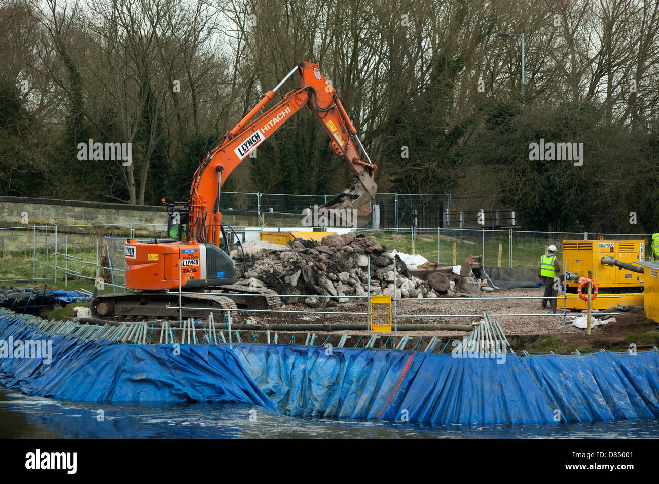 An Hitachi mechanical digger working on constructing a fish pass Stock ...