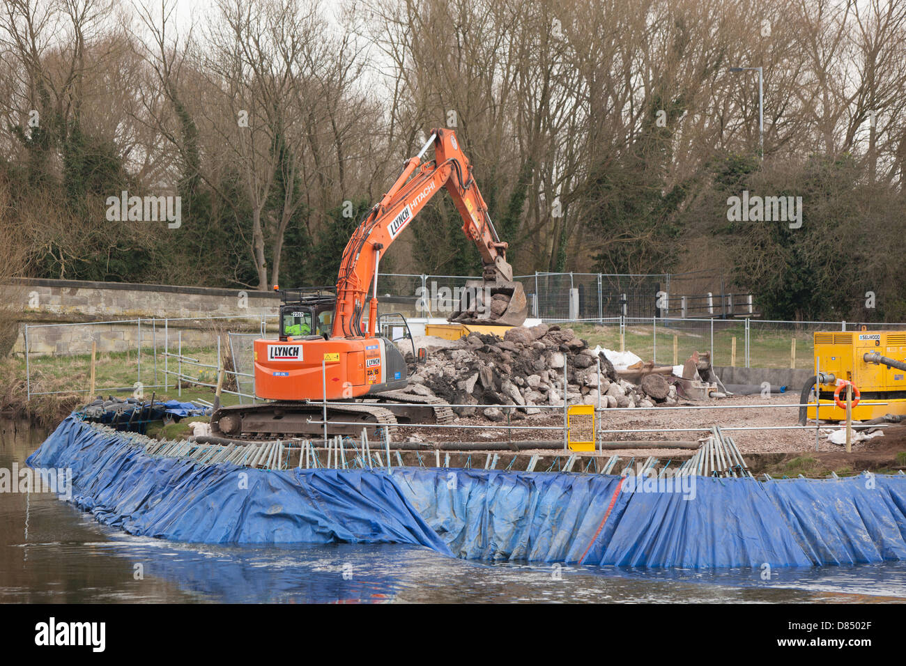 An Hitachi mechanical digger working on constructing a fish pass Stock ...