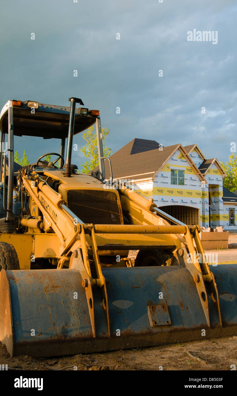 Backhoe in front of new residential homes under construction Stock ...