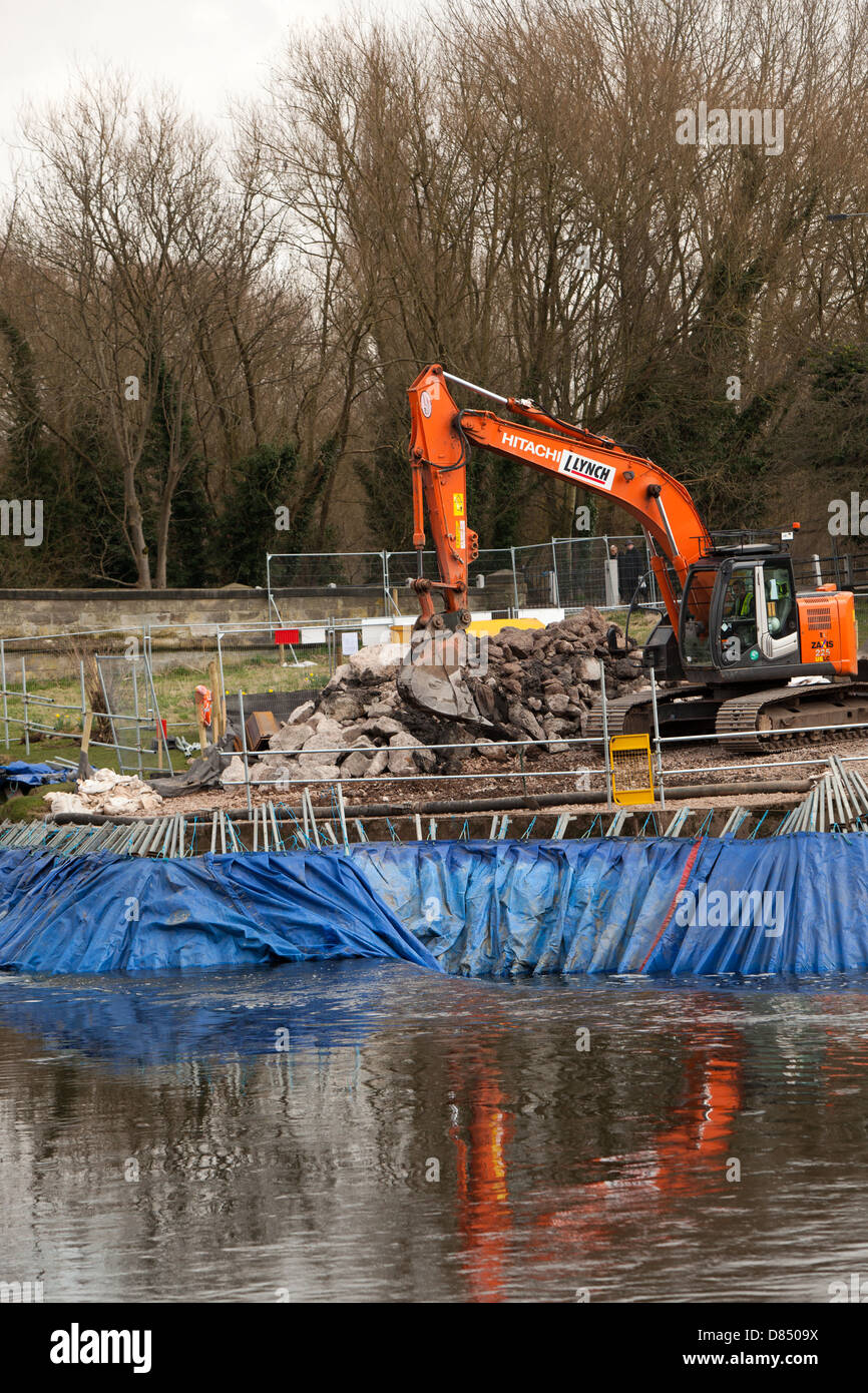 An Hitachi mechanical digger working on constructing a fish pass Stock ...