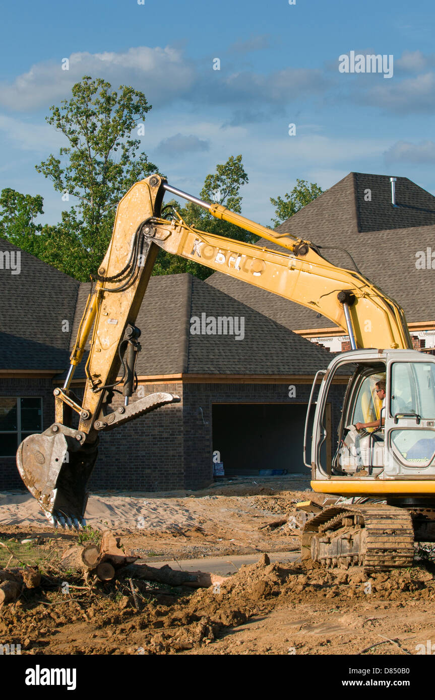 Backhoe clearing an empty lot and excavating a new residential home ...