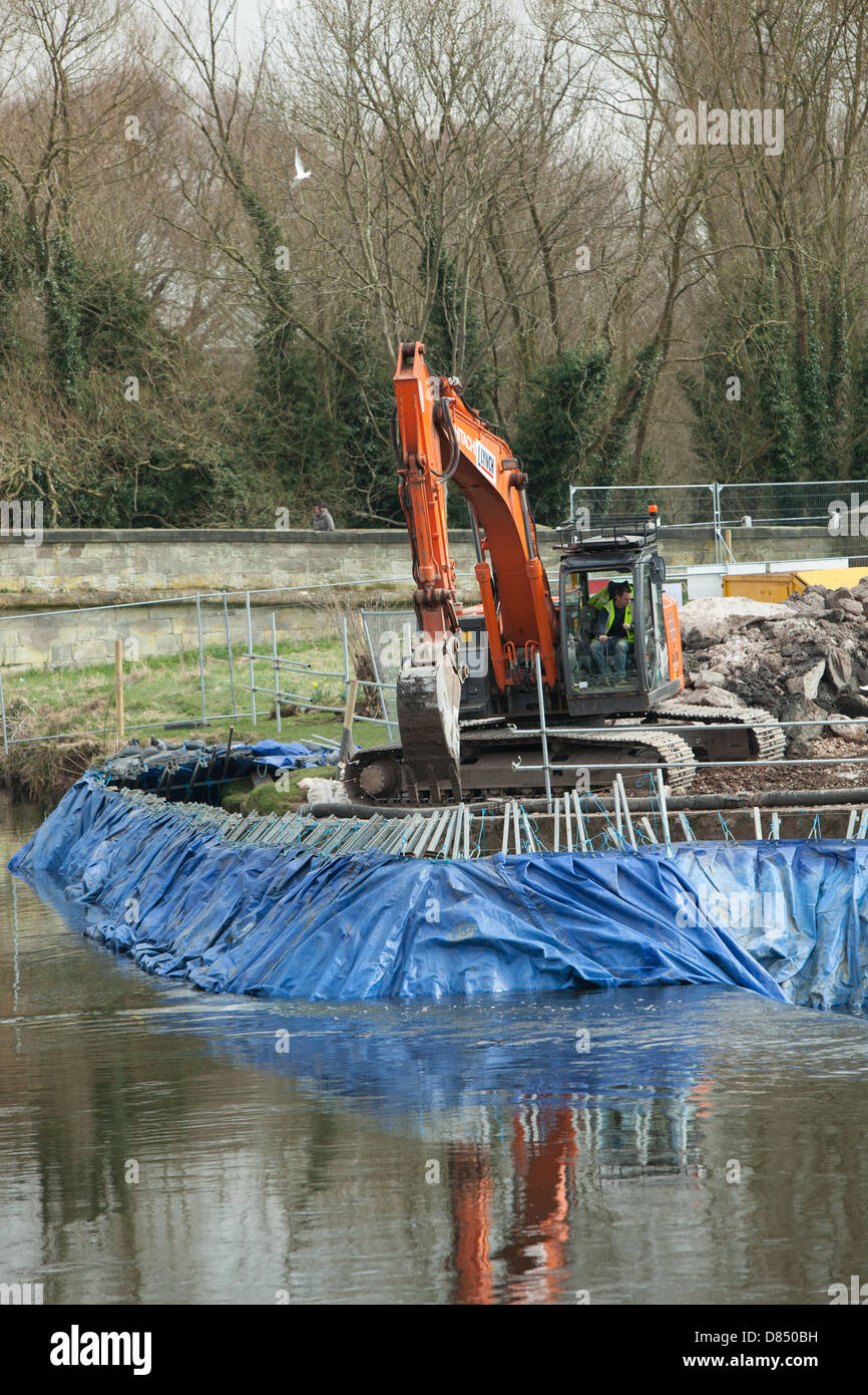 An Hitachi mechanical digger working on constructing a fish pass Stock ...
