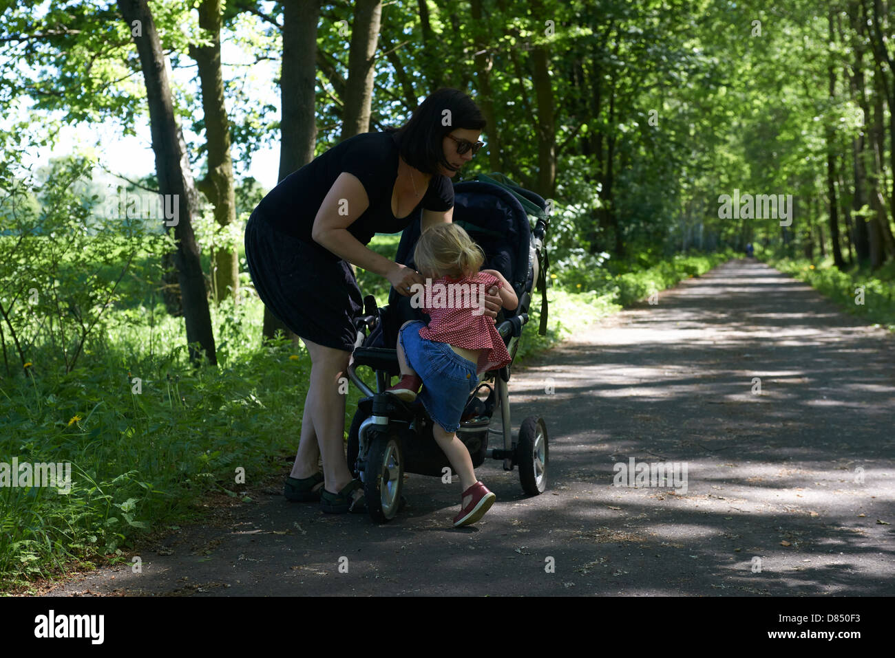 A mother with pushing pram summertime on bike way Stock Photo - Alamy