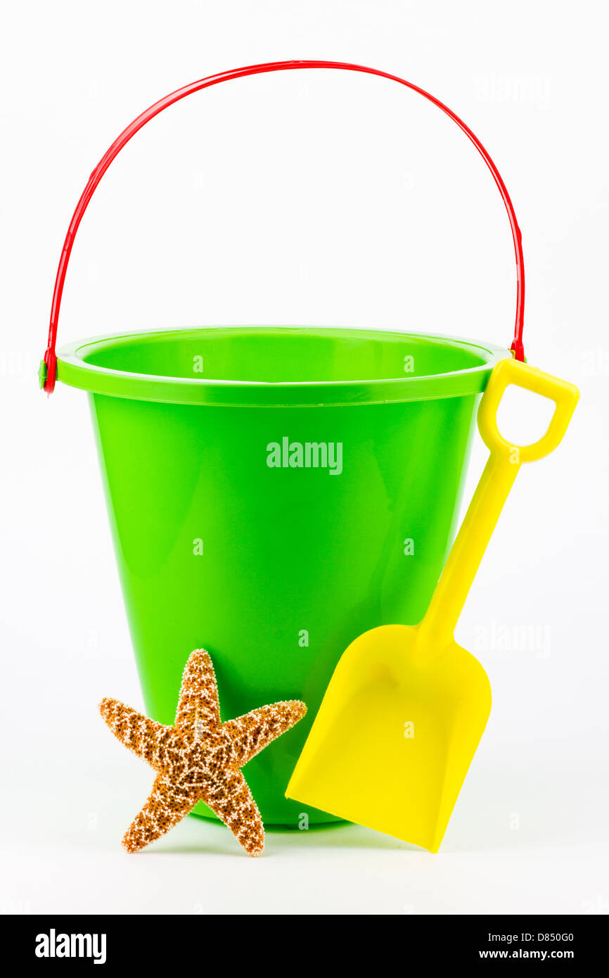 A green sand bucket with a yellow shovel and a starfish Stock Photo - Alamy