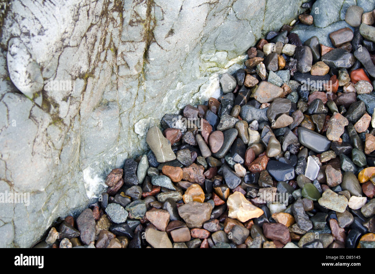Closeup view of small beach stones washed up against a smooth ...