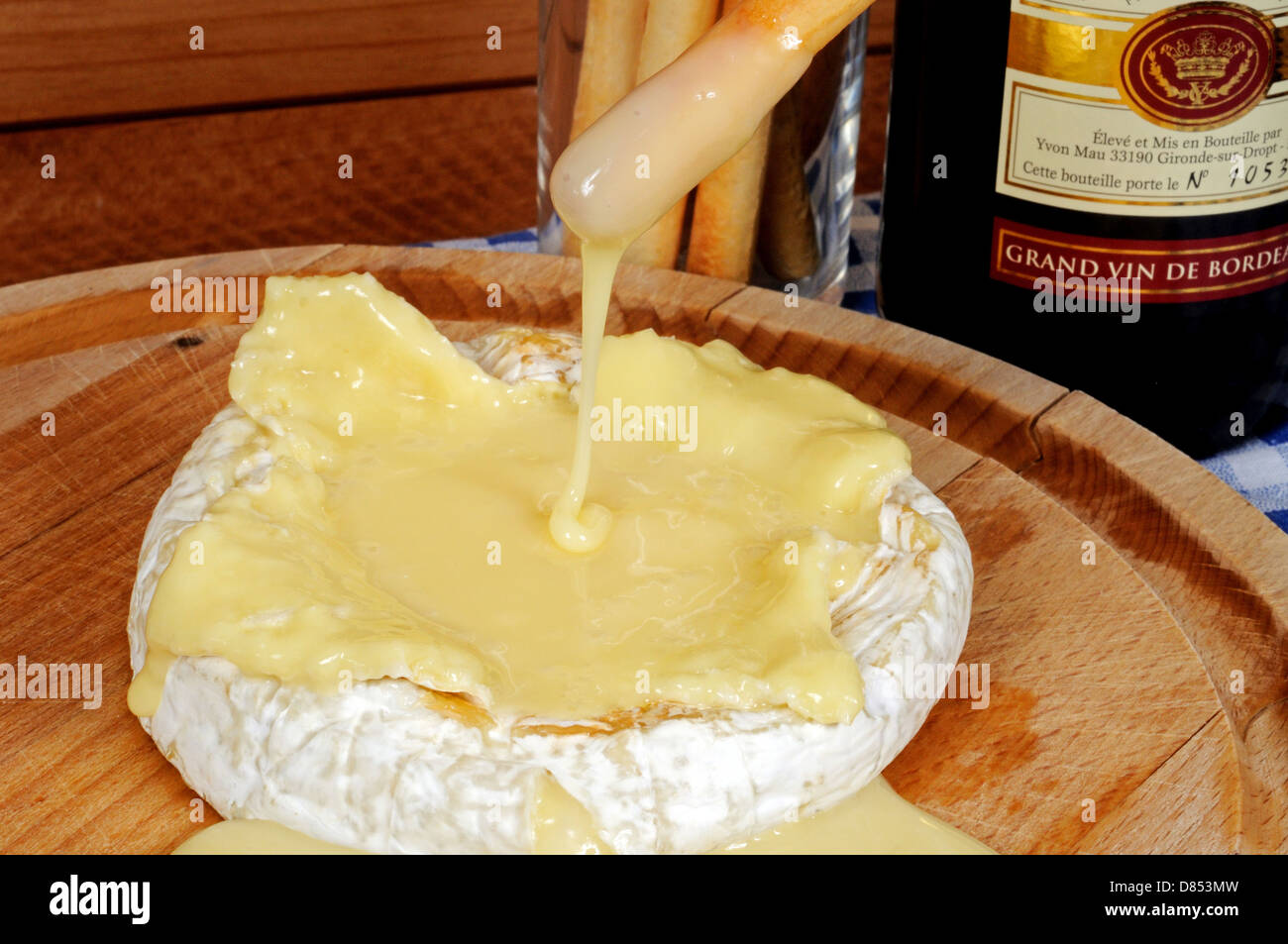 Baked whole French Camembert with Grissini breadsticks and a bottle of ...