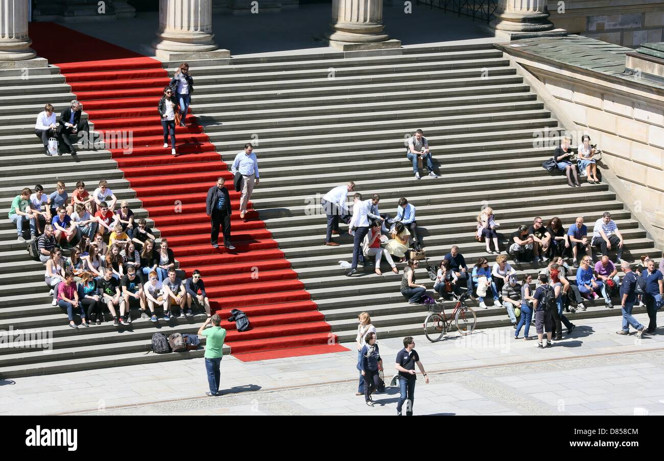 The sun shines onto a group of tourists sitting on the steps of the ...