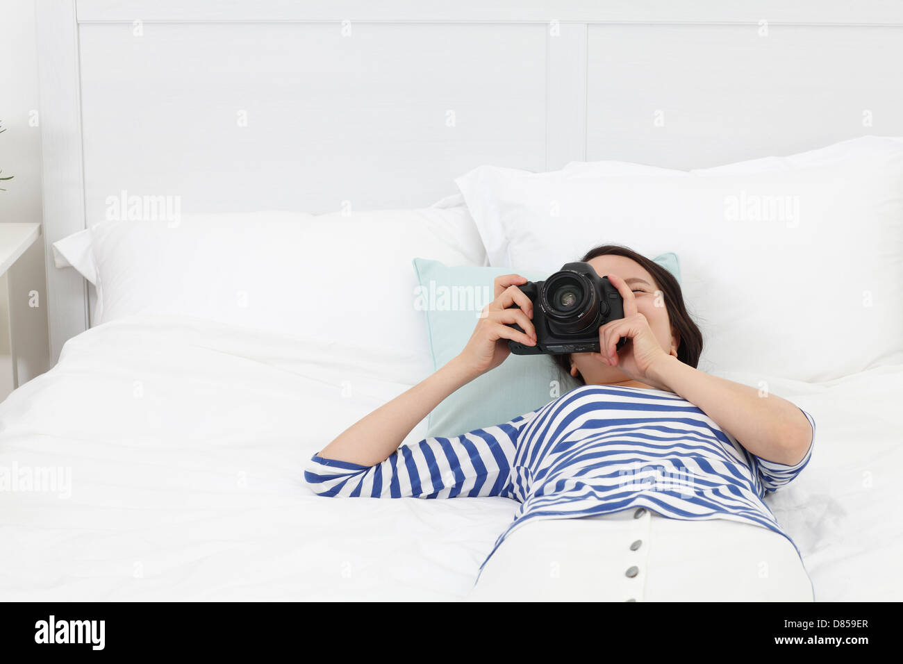 young woman on bed holding camera Stock Photo - Alamy