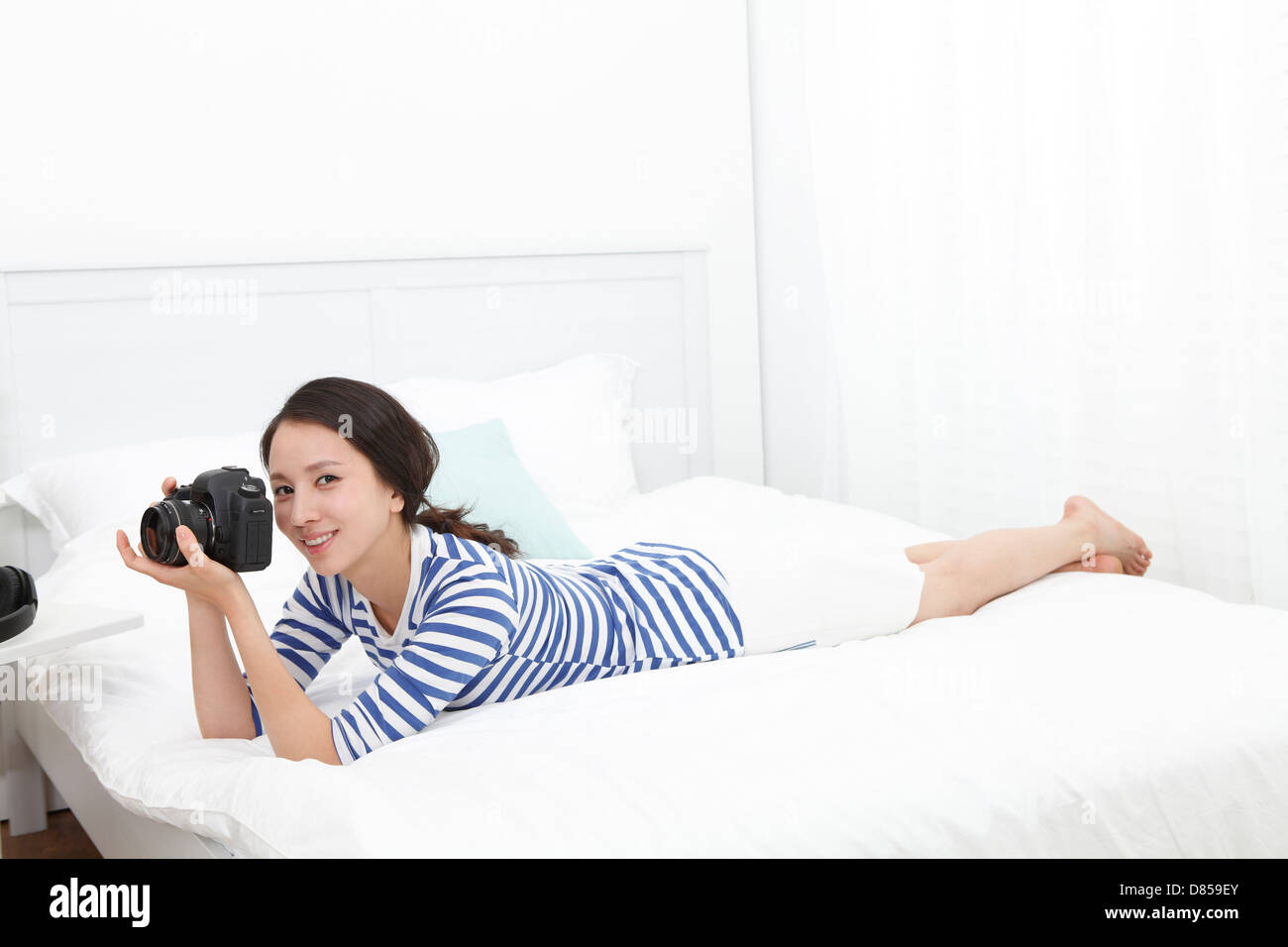 young woman on bed holding camera Stock Photo - Alamy