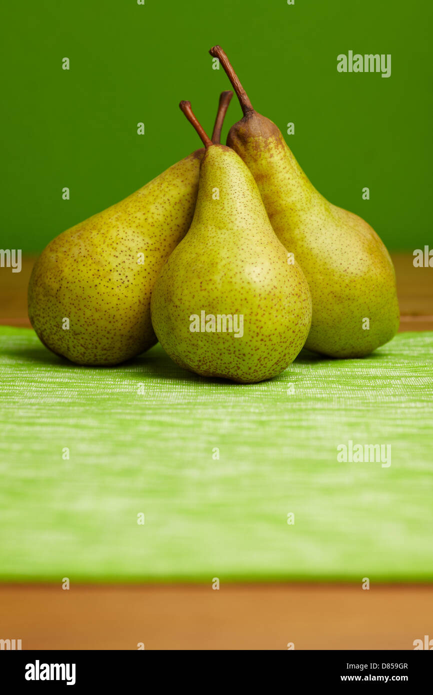 Three pears arranged in front of a green background Stock Photo - Alamy