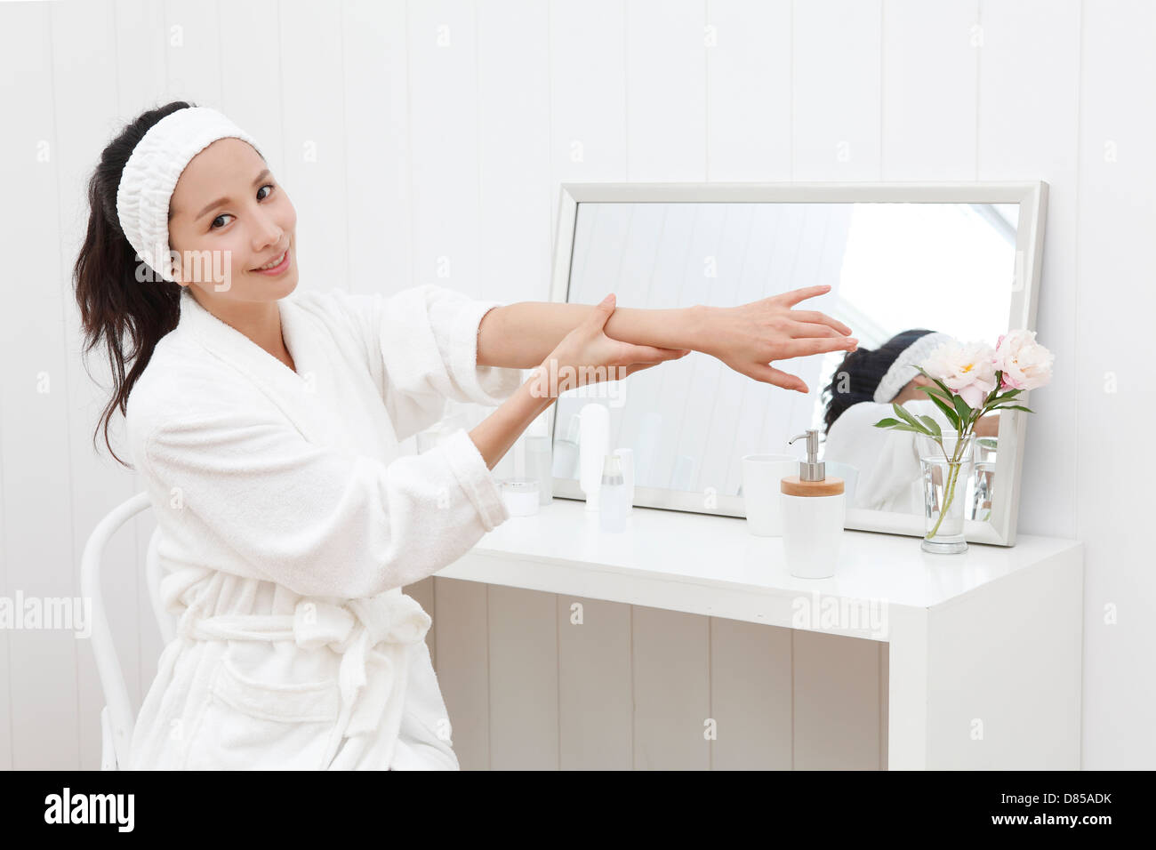 young woman applying body cream Stock Photo - Alamy