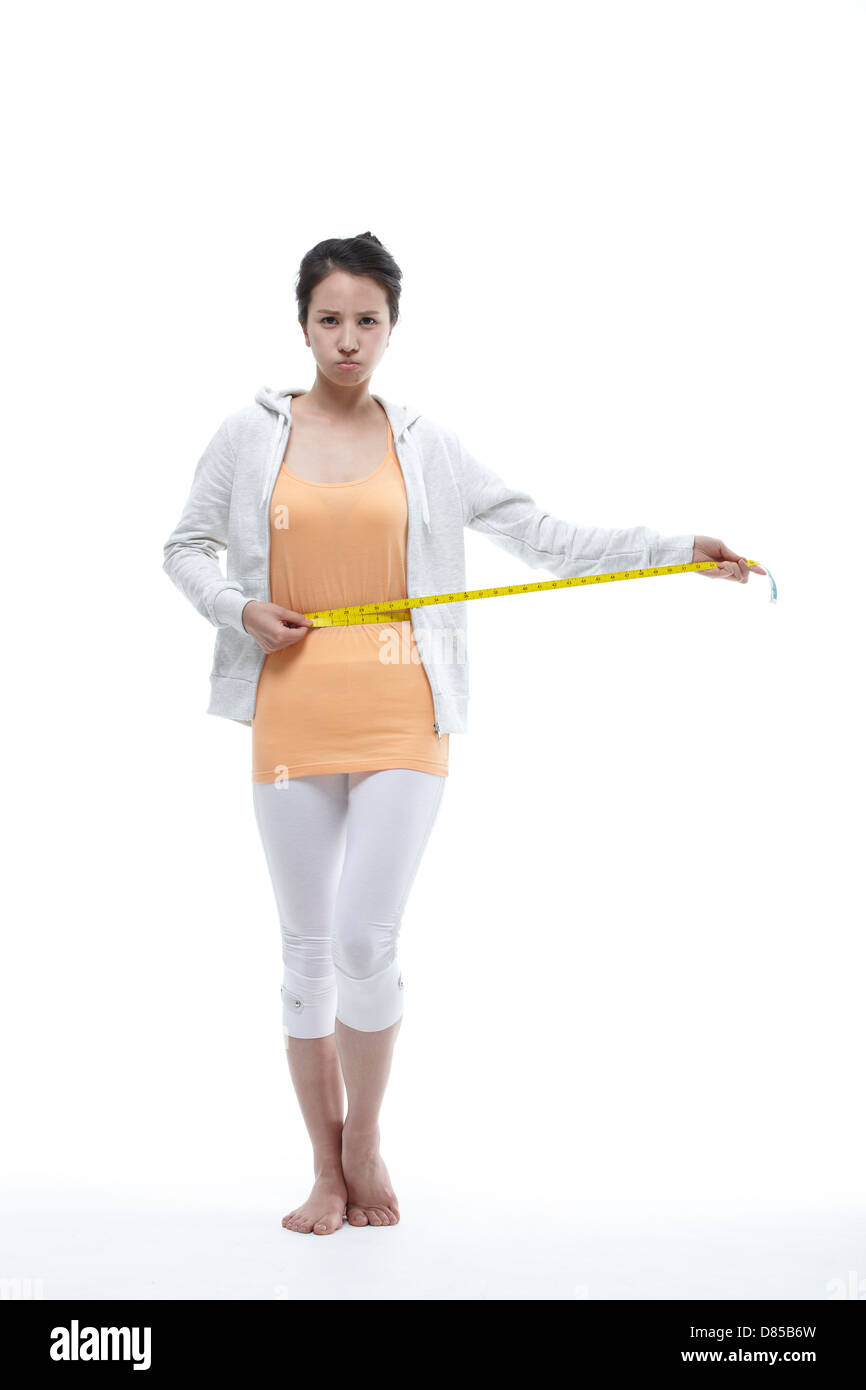 young woman measuring her waist Stock Photo - Alamy