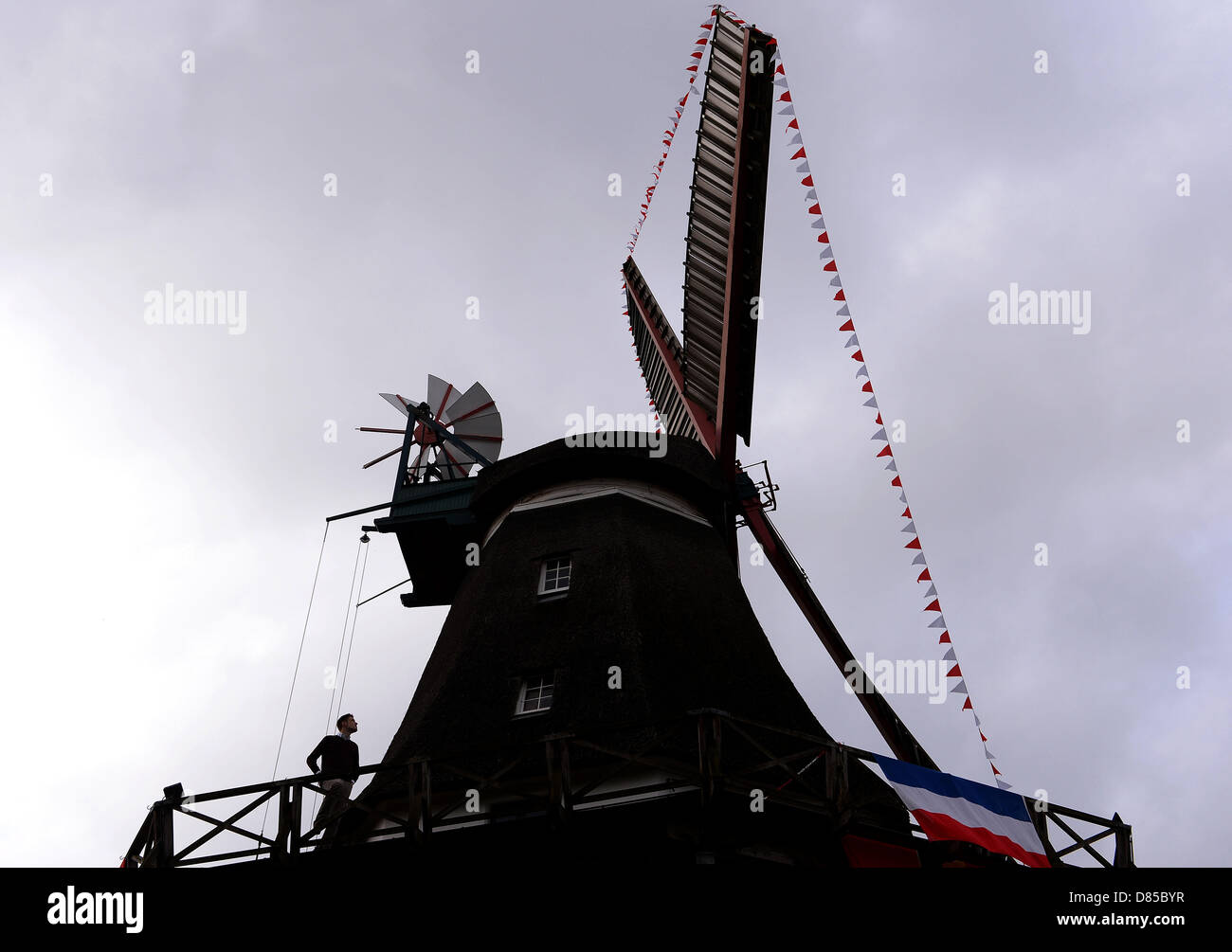 A man watches the blades of the Wilhelmsburg Mill in Hamburg, Germany ...