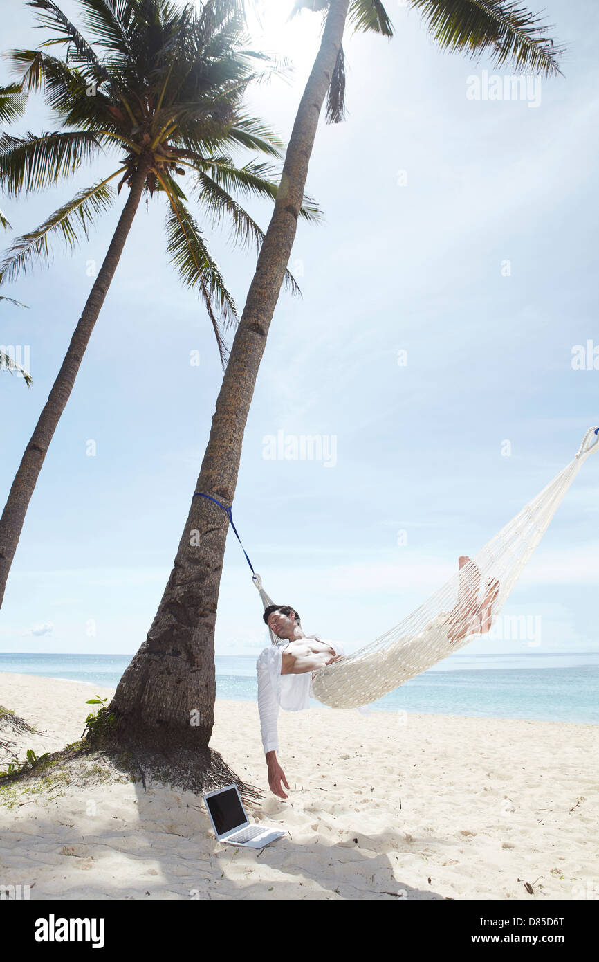 man relaxing in hammock on beach Stock Photo - Alamy