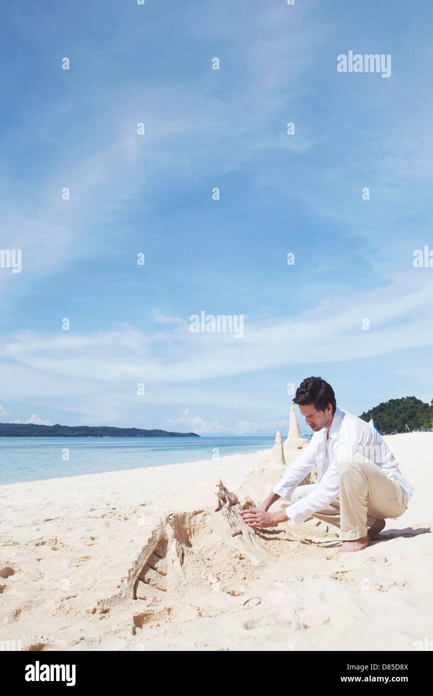 man building sandcastle Stock Photo - Alamy