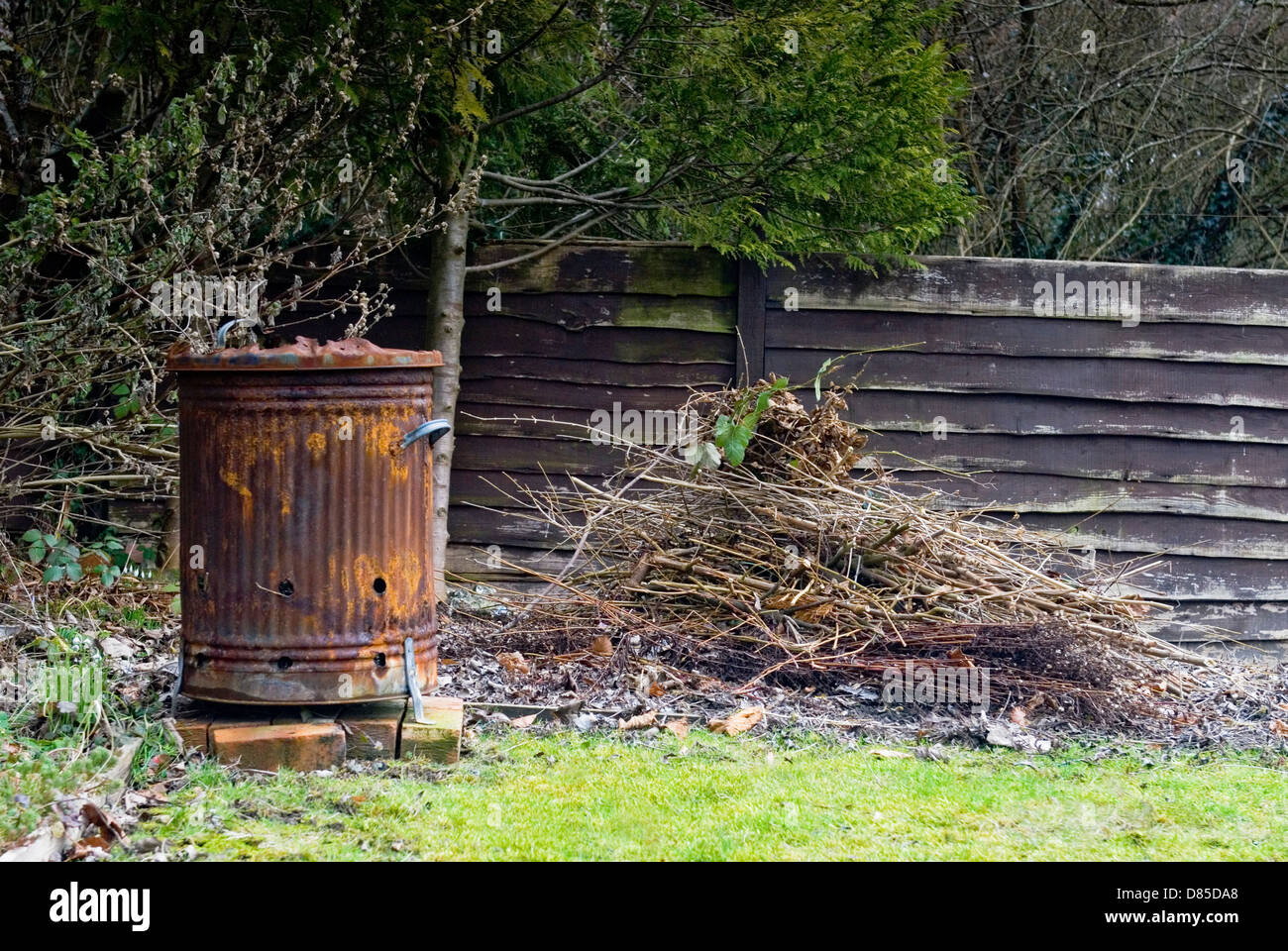 rusty bin ready to burn dry bushes in village garden Stock Photo - Alamy