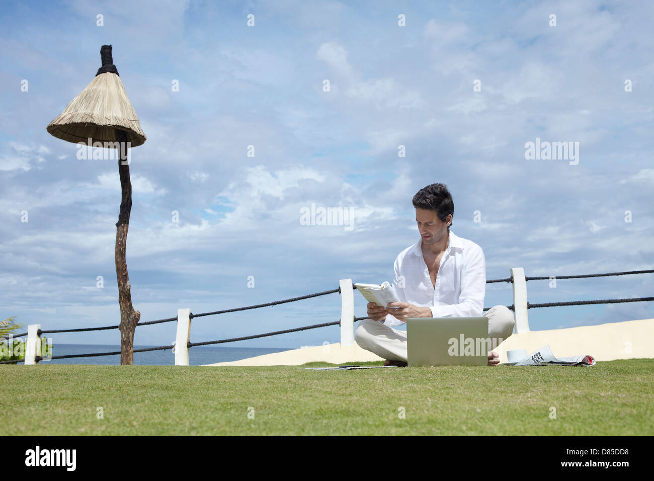 man sitting cross-legged on grass laptop Stock Photo - Alamy