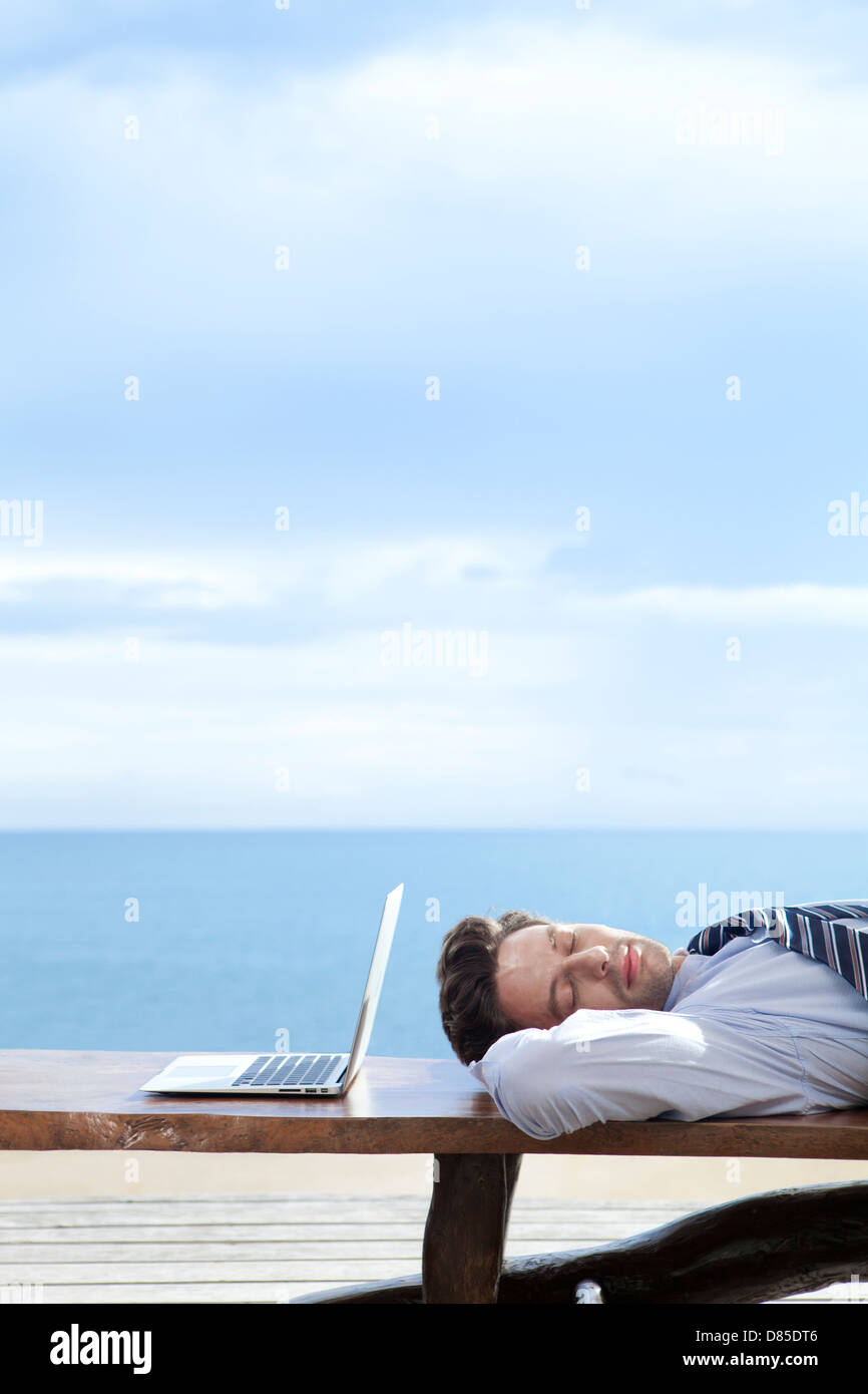 businessman lying on his back on table Stock Photo - Alamy