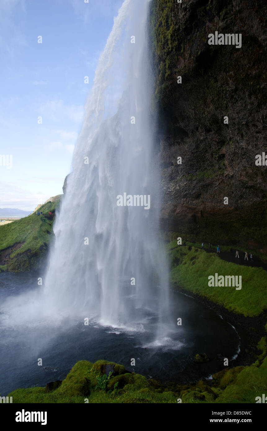 Seljalandsfoss water fall in Iceland from the side, with a few tourists ...
