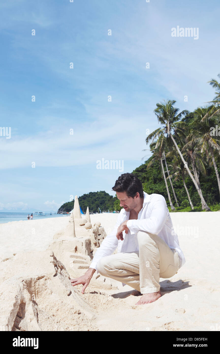 man building sandcastle Stock Photo - Alamy