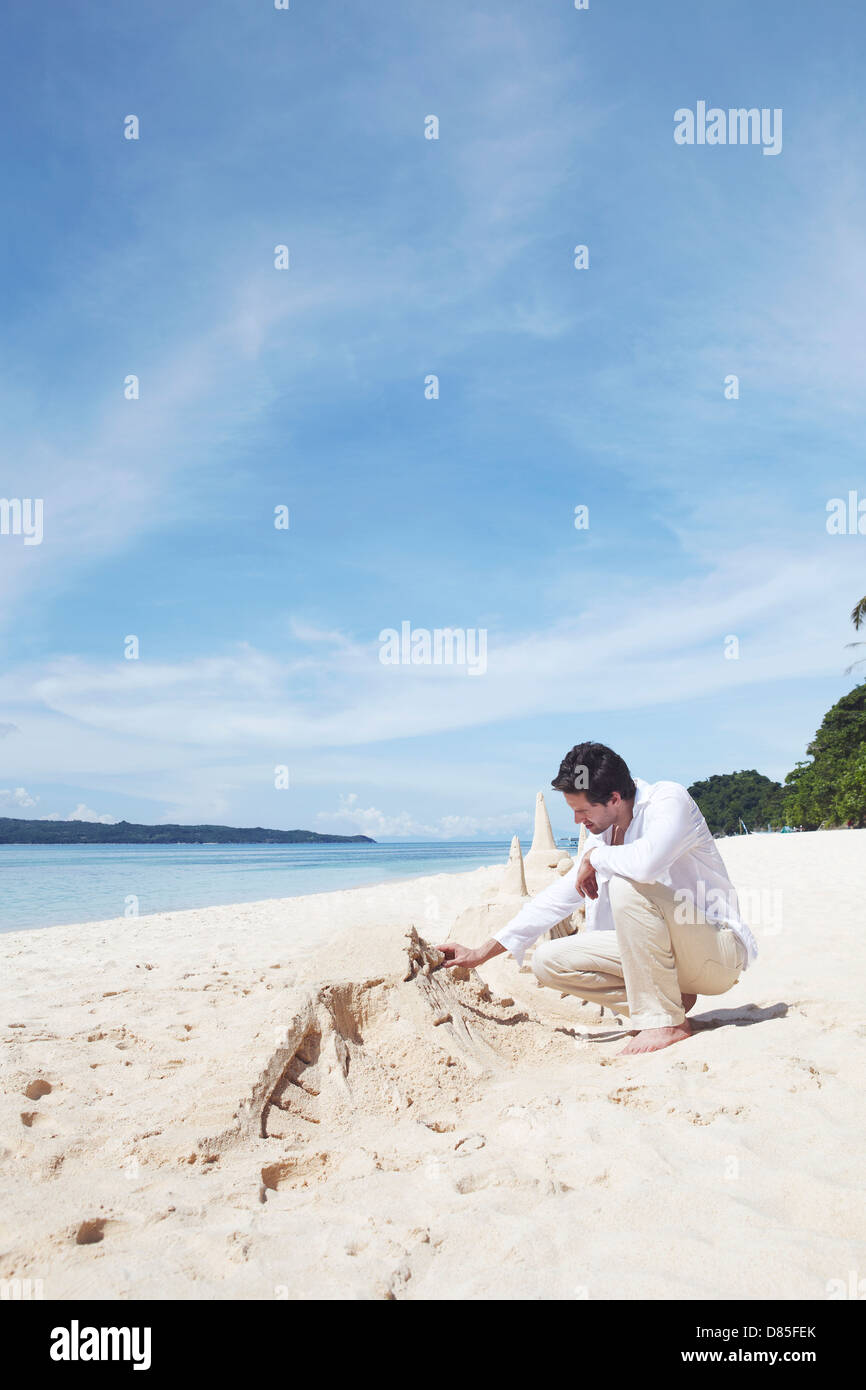 man building sandcastle Stock Photo - Alamy