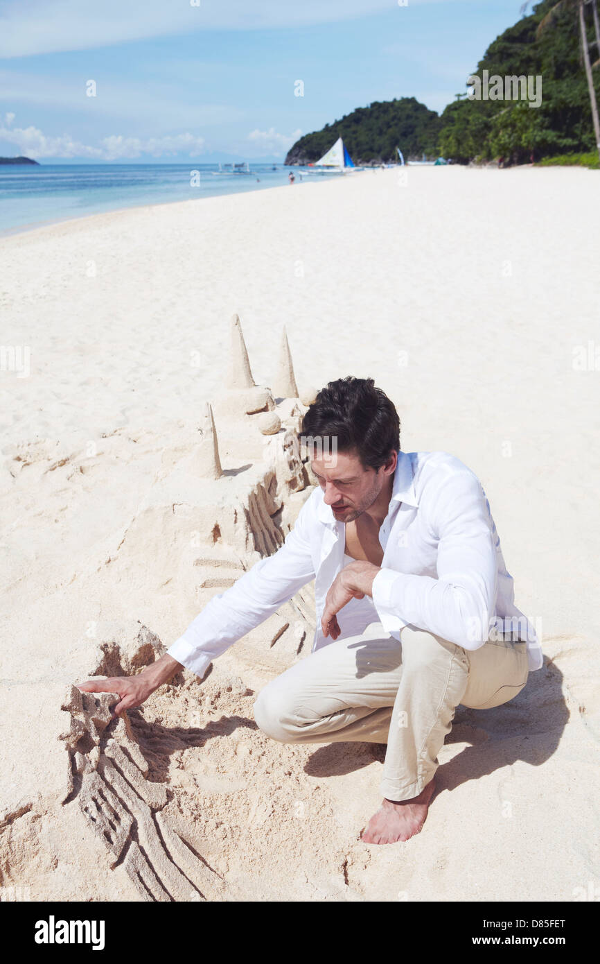 man building sandcastle Stock Photo - Alamy