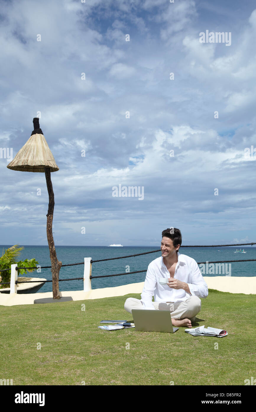 man sitting on grass working on laptop Stock Photo - Alamy