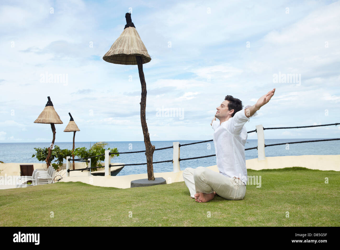 man sitting on grass stretching Stock Photo - Alamy