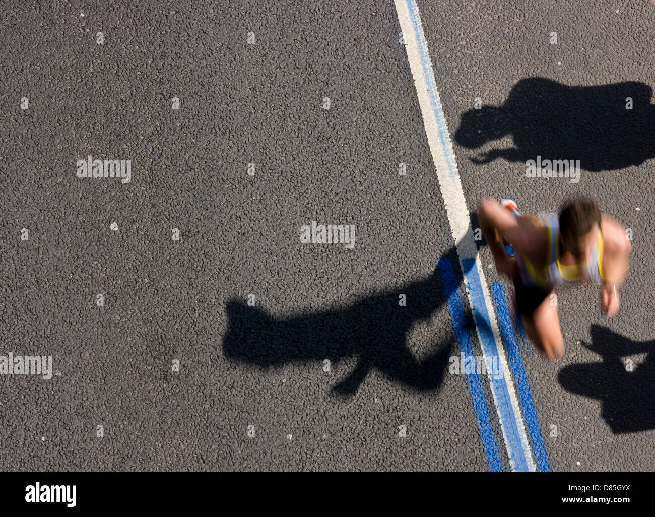 Marathon runner motion blur and shadows silhouette of spectators ...