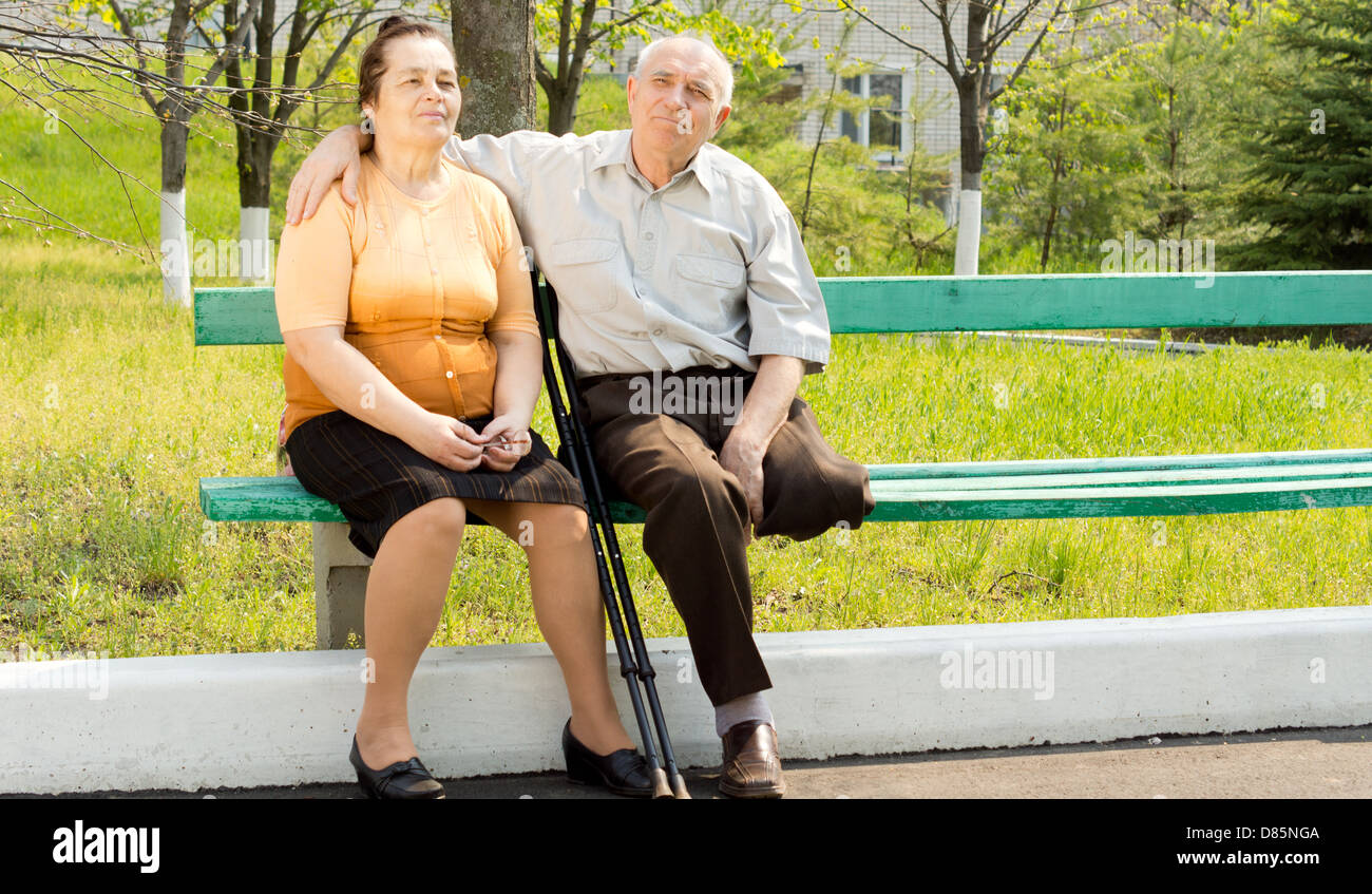 Sweet couple talking and sitting on the bench park Stock Photo - Alamy