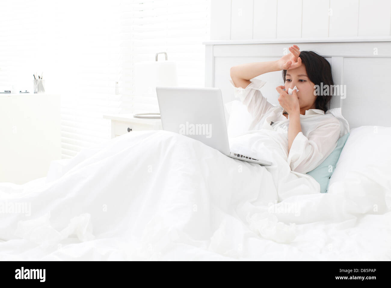 sick young woman studying in bed Stock Photo - Alamy