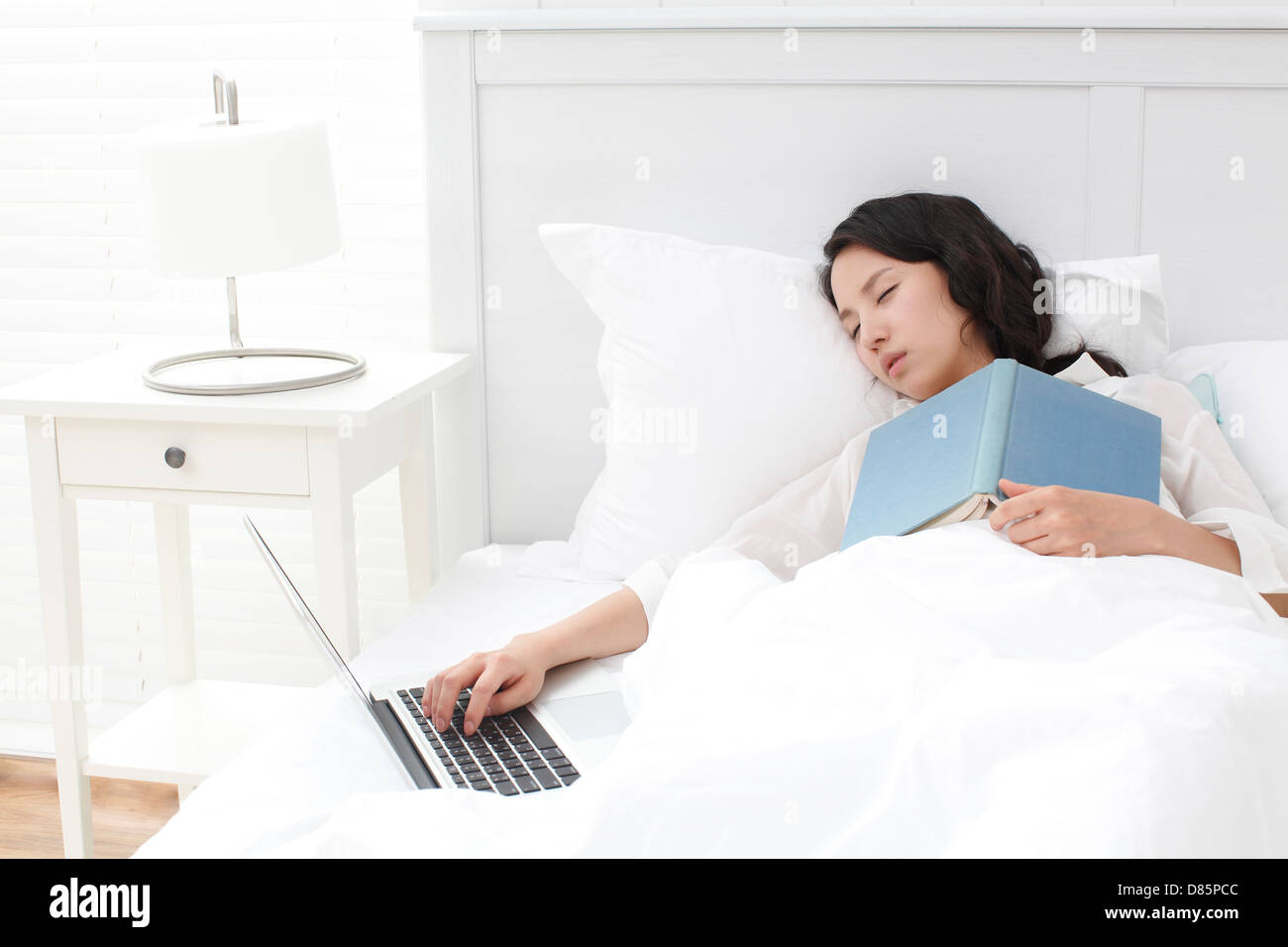 sick young woman studying in bed Stock Photo - Alamy