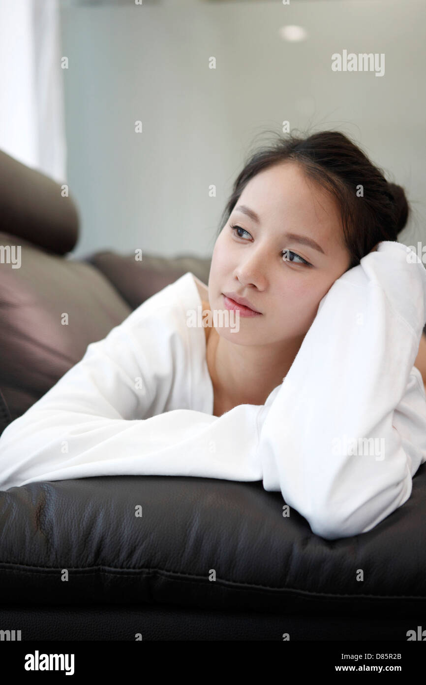 young woman lying on her front on sofa Stock Photo - Alamy
