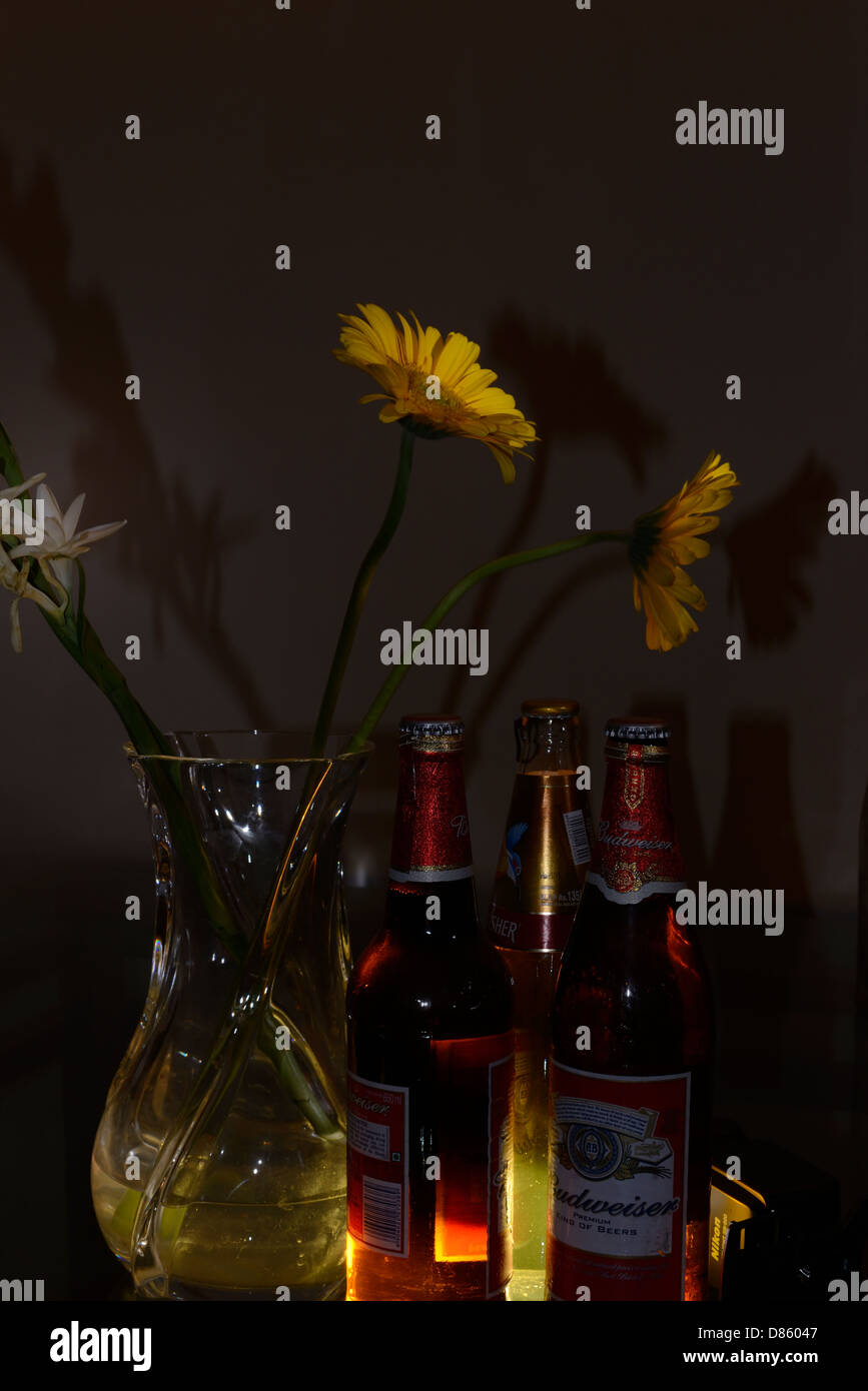 Yellow flower among beer bottles Stock Photo - Alamy
