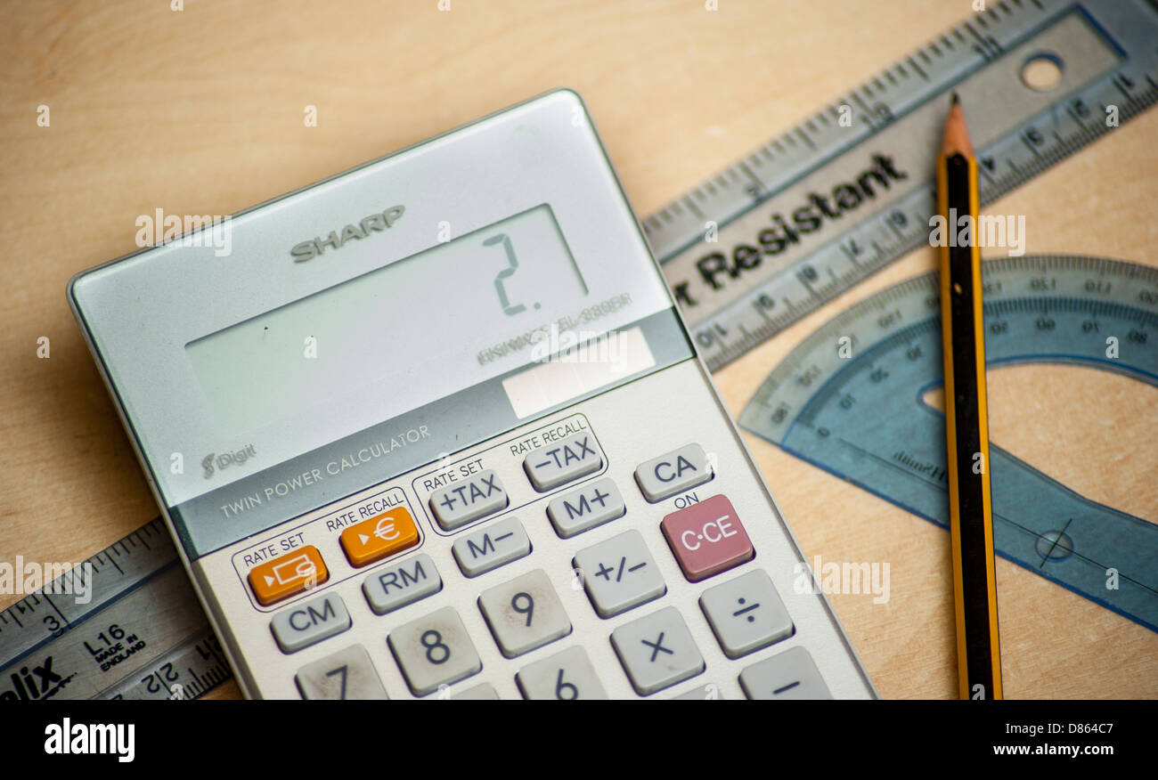 A maths calculator on a table with rulers and a pencil to represent ...