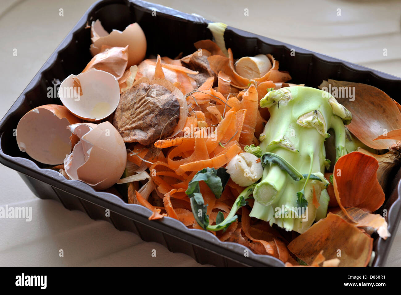 Household kitchen vegetable waste in a re-used food container ready for ...