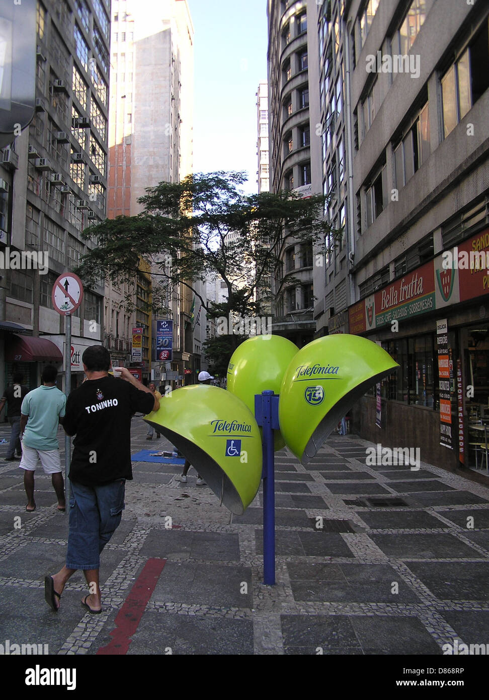 A traditional red telephone booth stands in a street of São Paulo ...