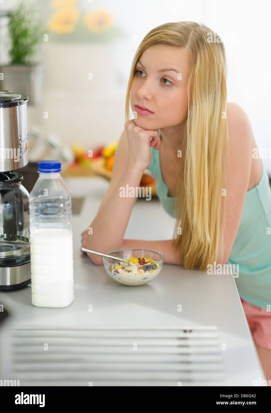 Thoughtful teenager girl having breakfast in kitchen Stock Photo - Alamy