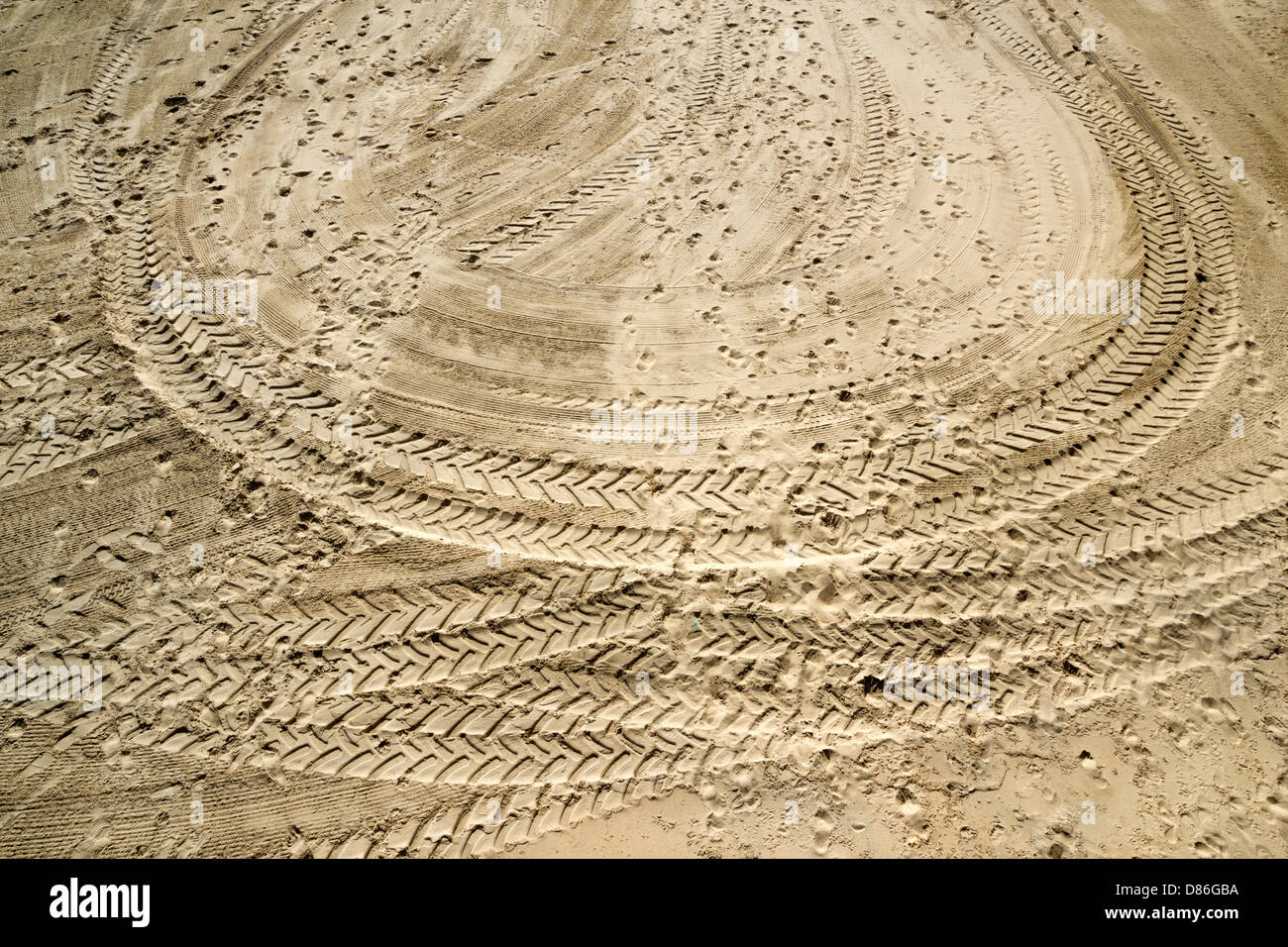 Tractor Tyre tracks in a loop and footprints on sand Stock Photo - Alamy