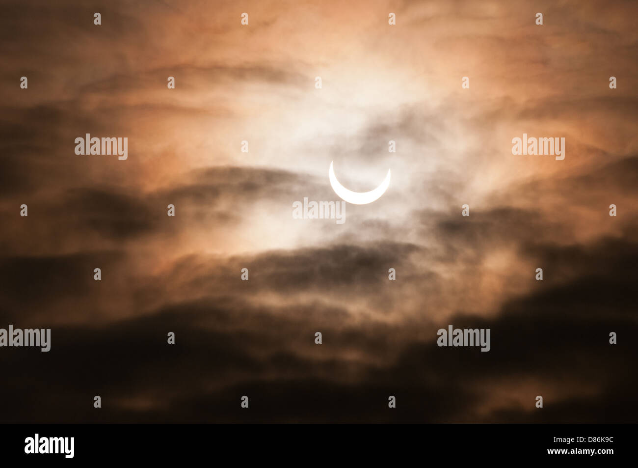 Partial solar eclipse behind clouds morning sky Stock Photo - Alamy