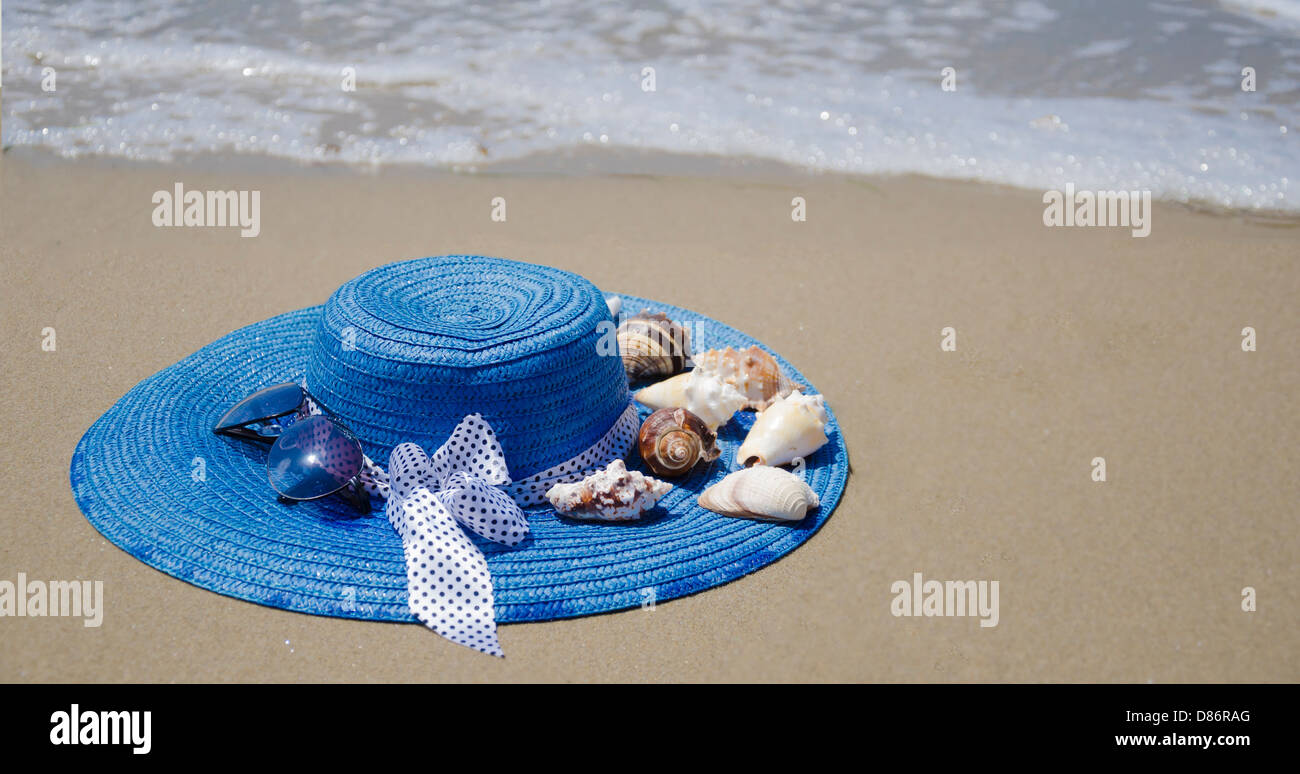 Blue summer woman's hat with seashells on beach's sand Stock Photo - Alamy