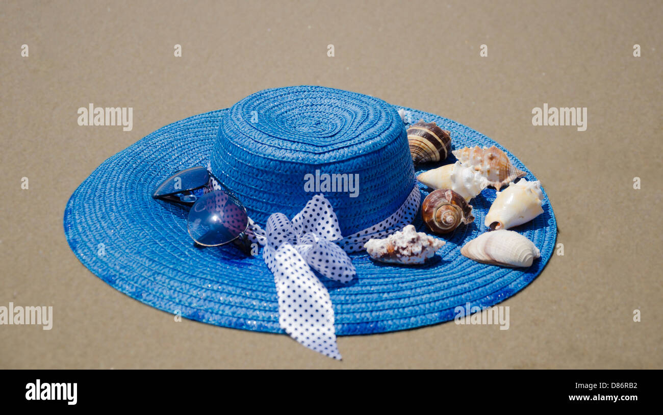 Blue summer woman's hat with seashells on beach's sand Stock Photo - Alamy