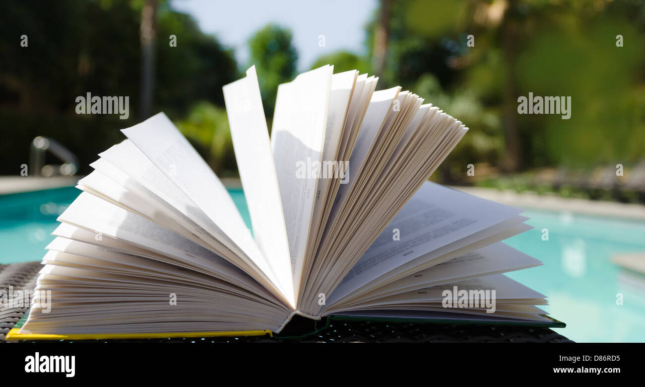 Open book by the swimming pool Stock Photo - Alamy