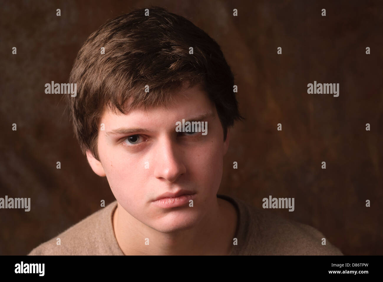 Troubled Teen waiting alone in studio shot Stock Photo - Alamy