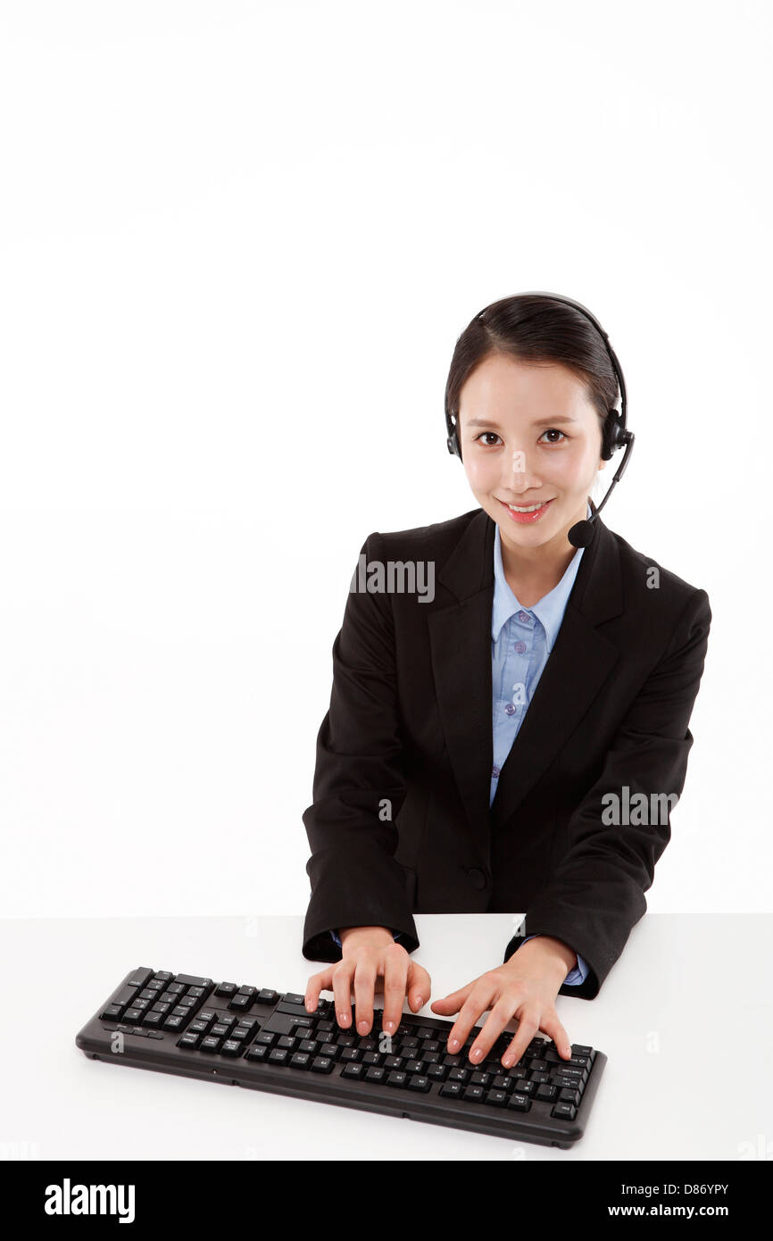 young woman sitting desk typing Stock Photo - Alamy