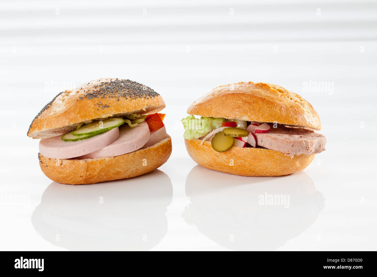 Variety of bread rolls sandwiches with mixed cold cuts on white ...