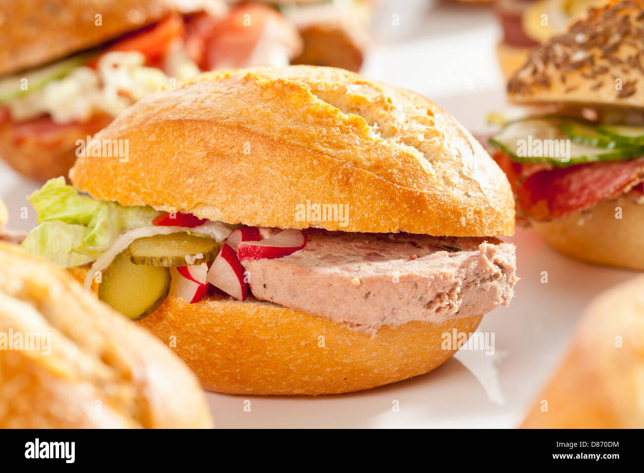 Variety of bread rolls sandwiches with mixed cold cuts on white ...