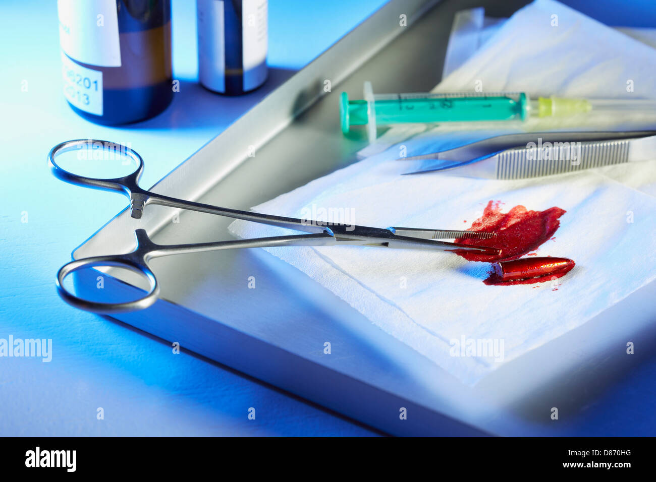 Surgical tray with bullet, tweezers, blood and syringe, close up Stock ...