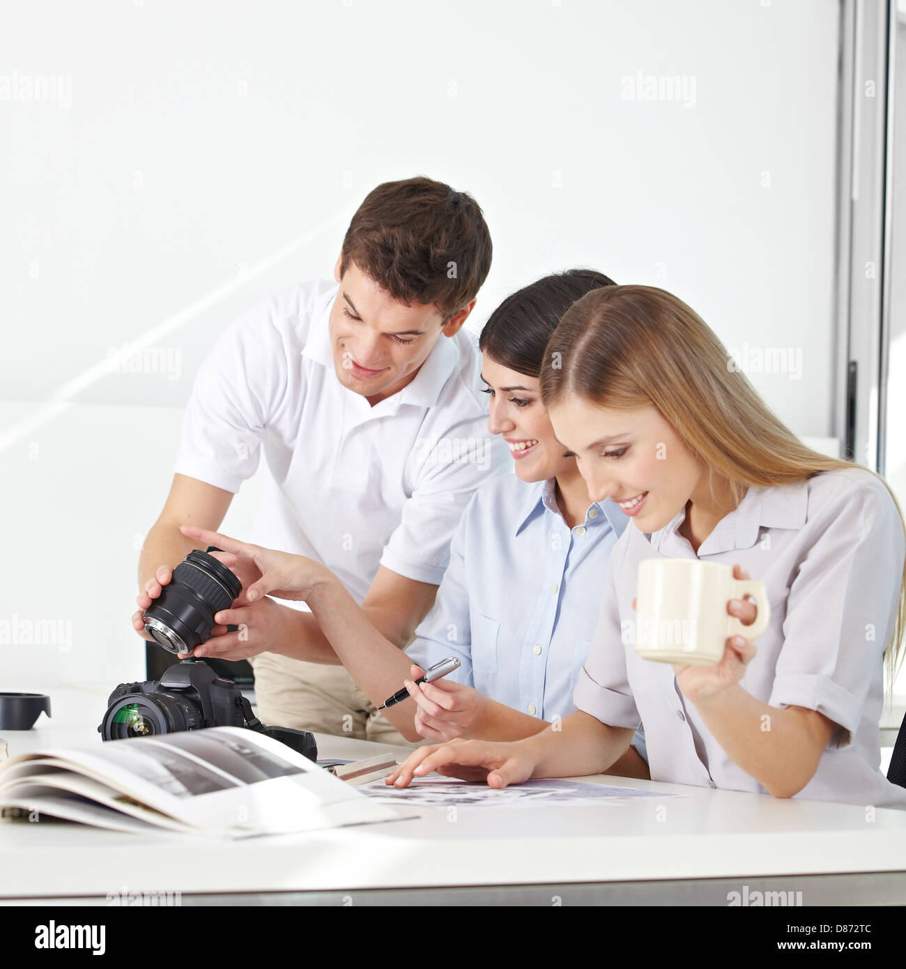 Teacher in photo workshop with students explaining a camera Stock Photo ...